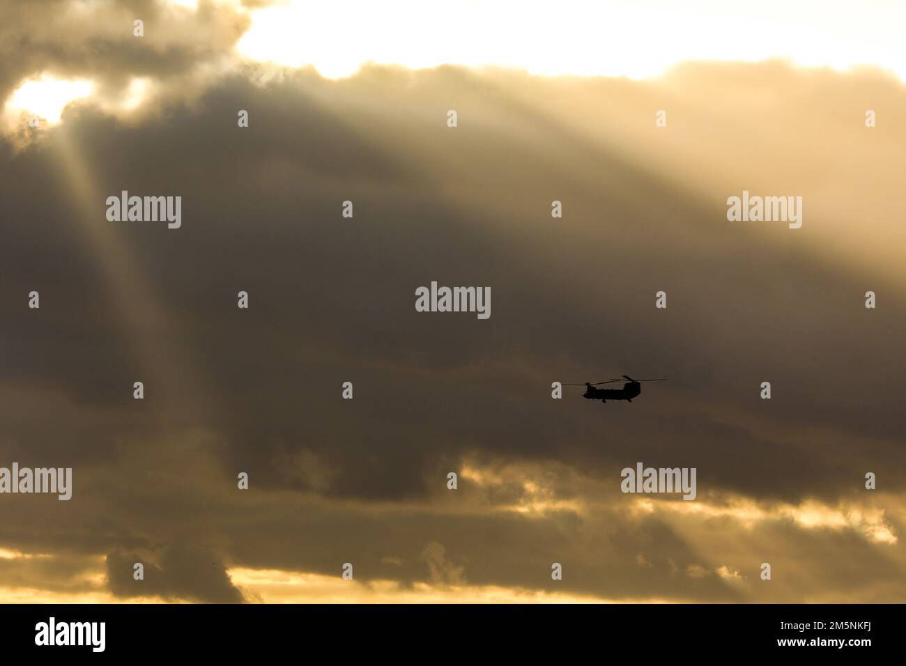 A U.S. Army CH-47 Chinook helicopter soars at sunset over the Poland ...