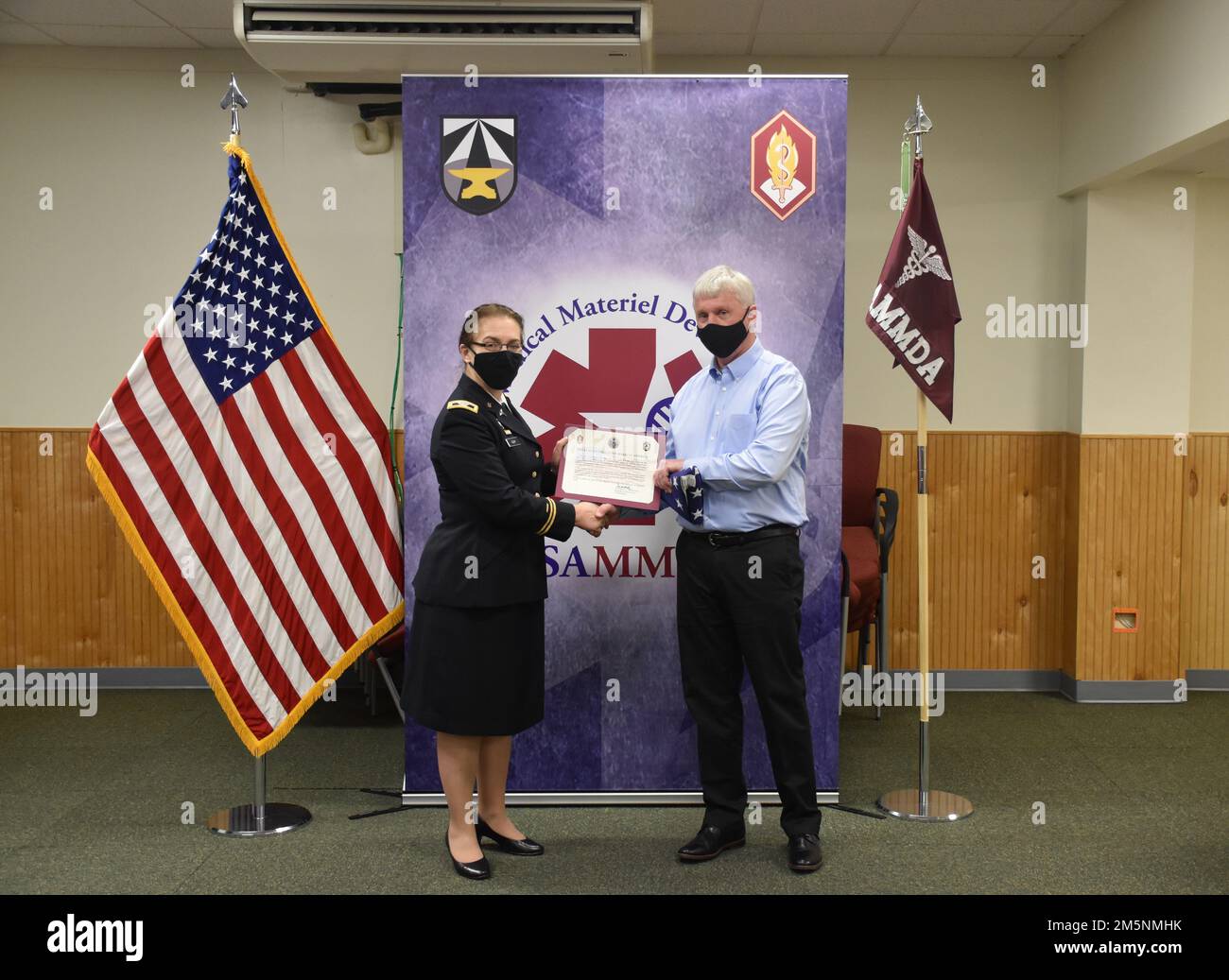 Army Col. Gina E. Adam, USAMMDA commander, presents Mark Brown with a ...