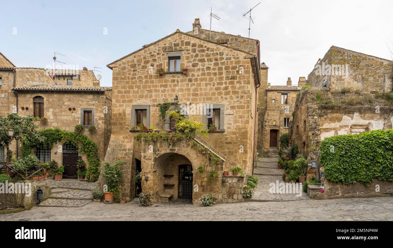 Old tufa buildings decorated with flowers in the hilltop village of ...