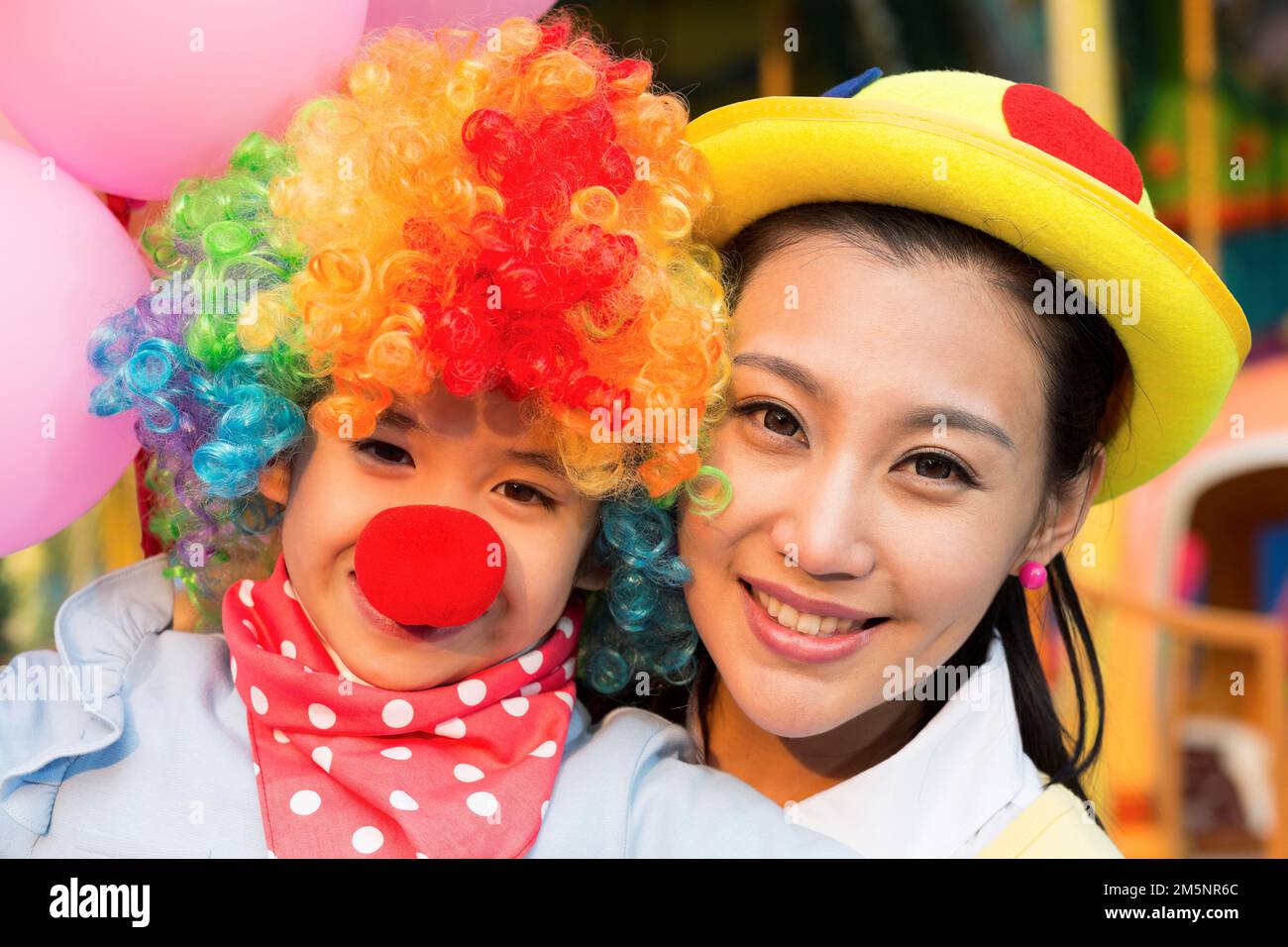 A young mother and daughter dressed as a clown in the amusement park to play Stock Photo - Alamy