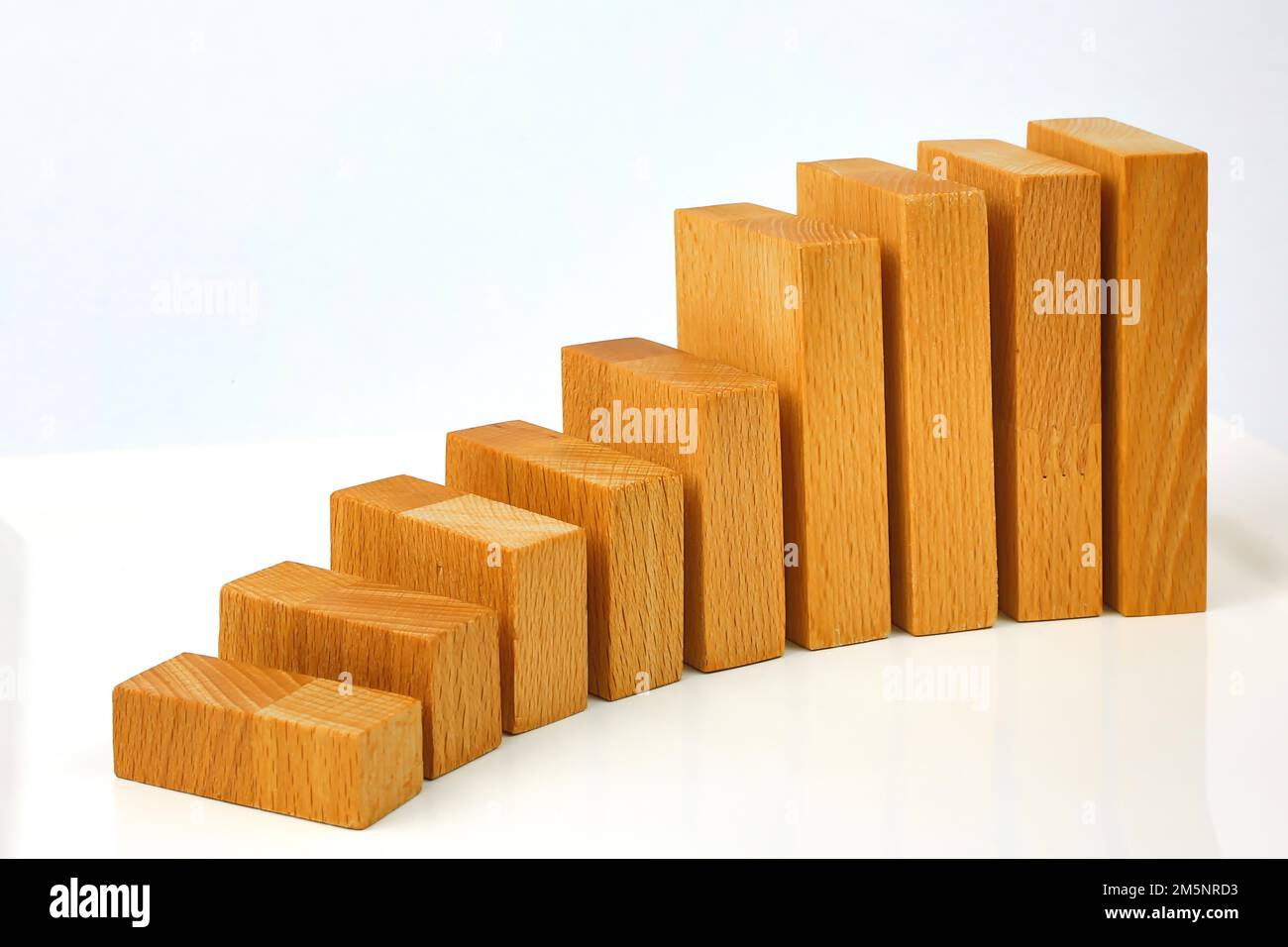 Wooden blocks are set up like a chart or a staircase, set against a ...