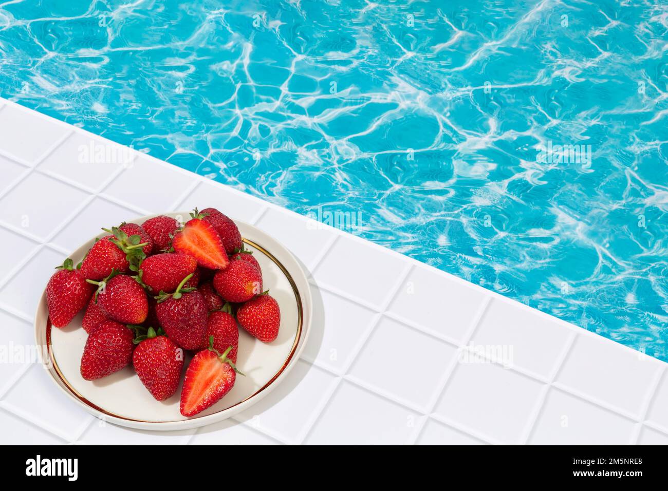 Strawberry platter on the pool and marble floor Stock Photo - Alamy