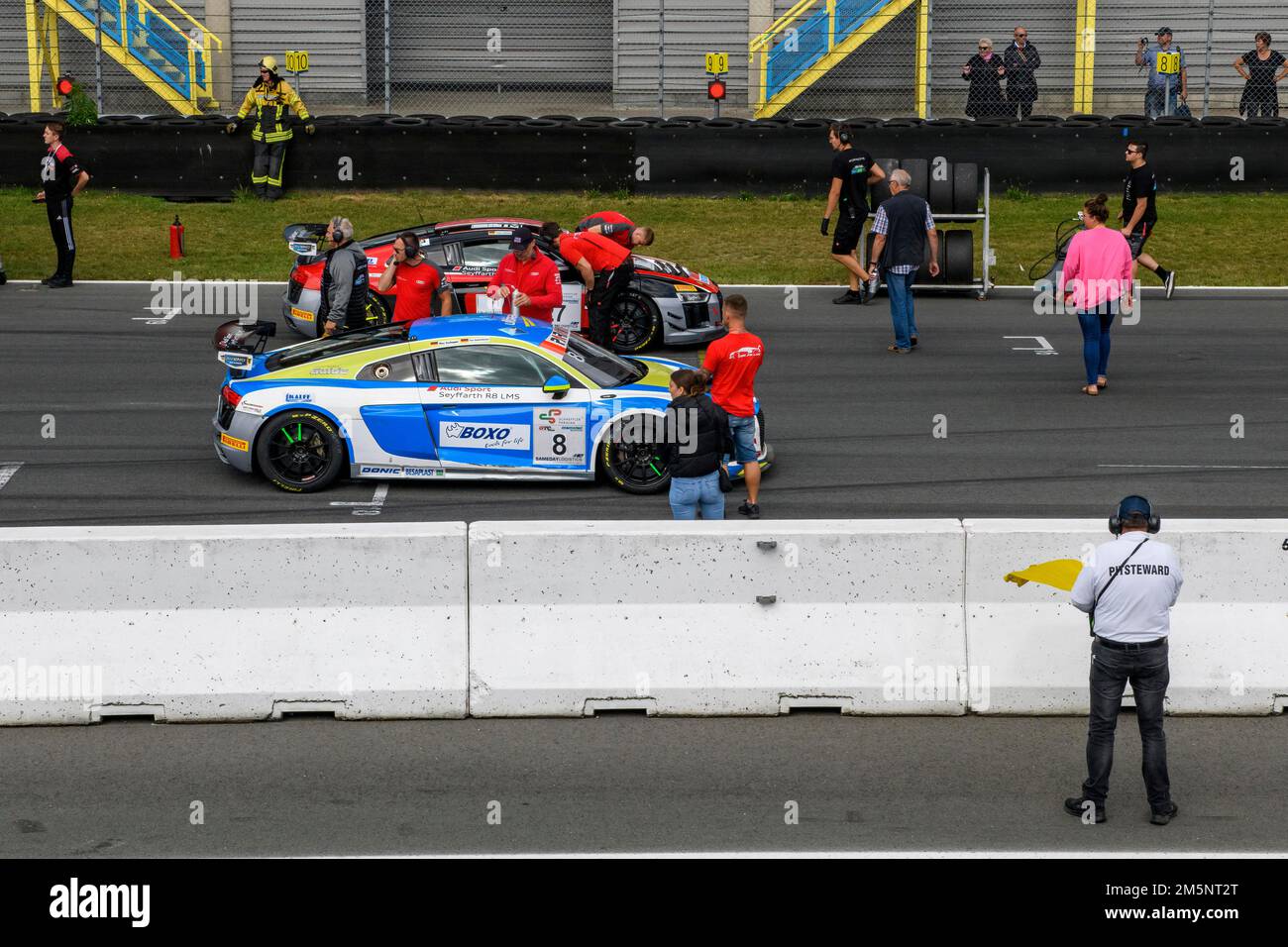 Mechanics prepare two race car sports car Audi R8 LMS GT4 on grid lane ...