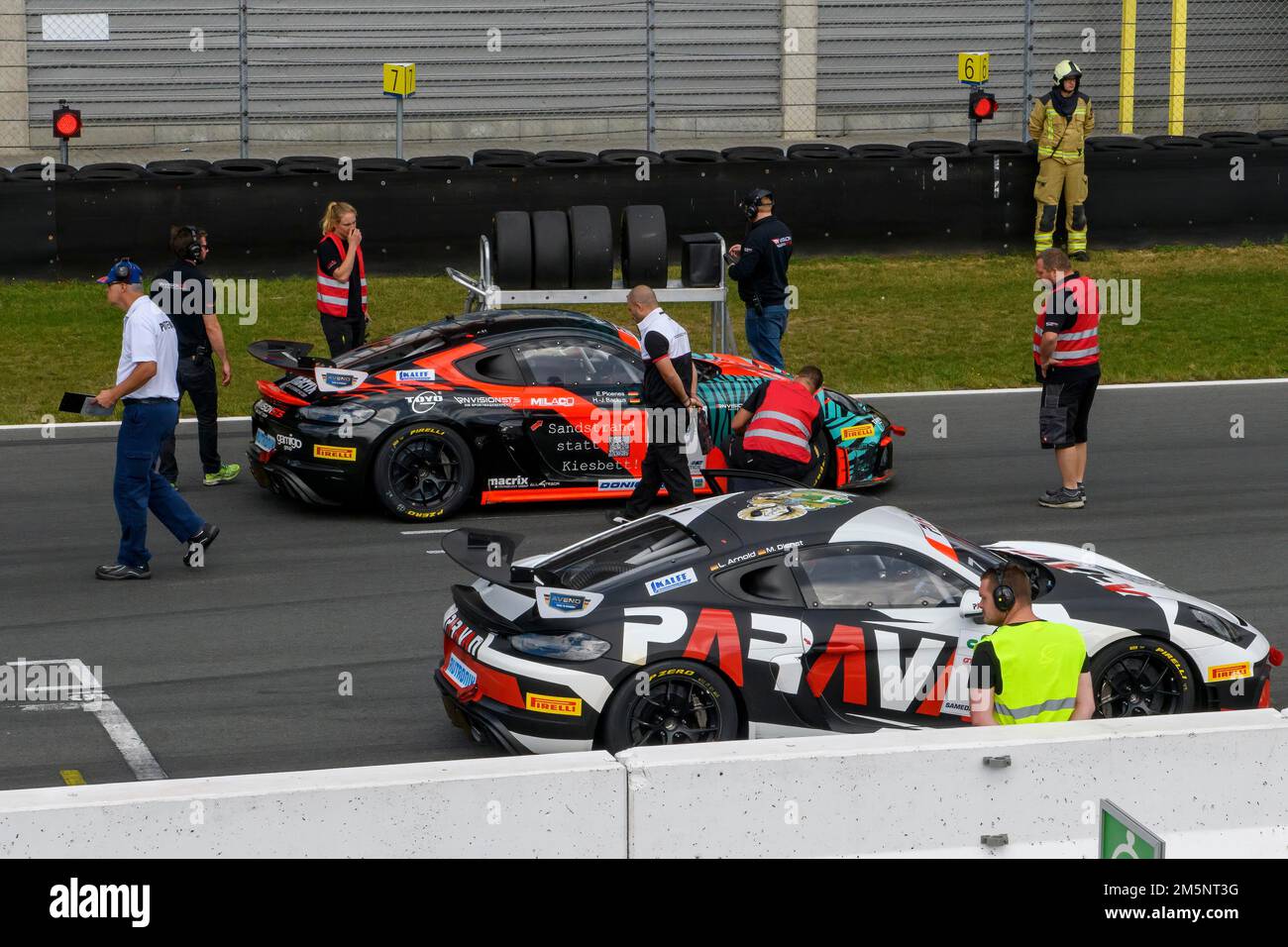 Two racing sports cars in the background Mechanics prepare Porsche ...