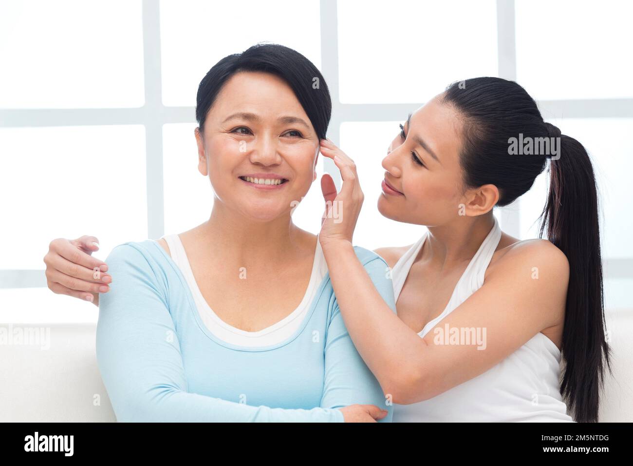 Intimate mother-daughter cuddling on the sofa Stock Photo - Alamy