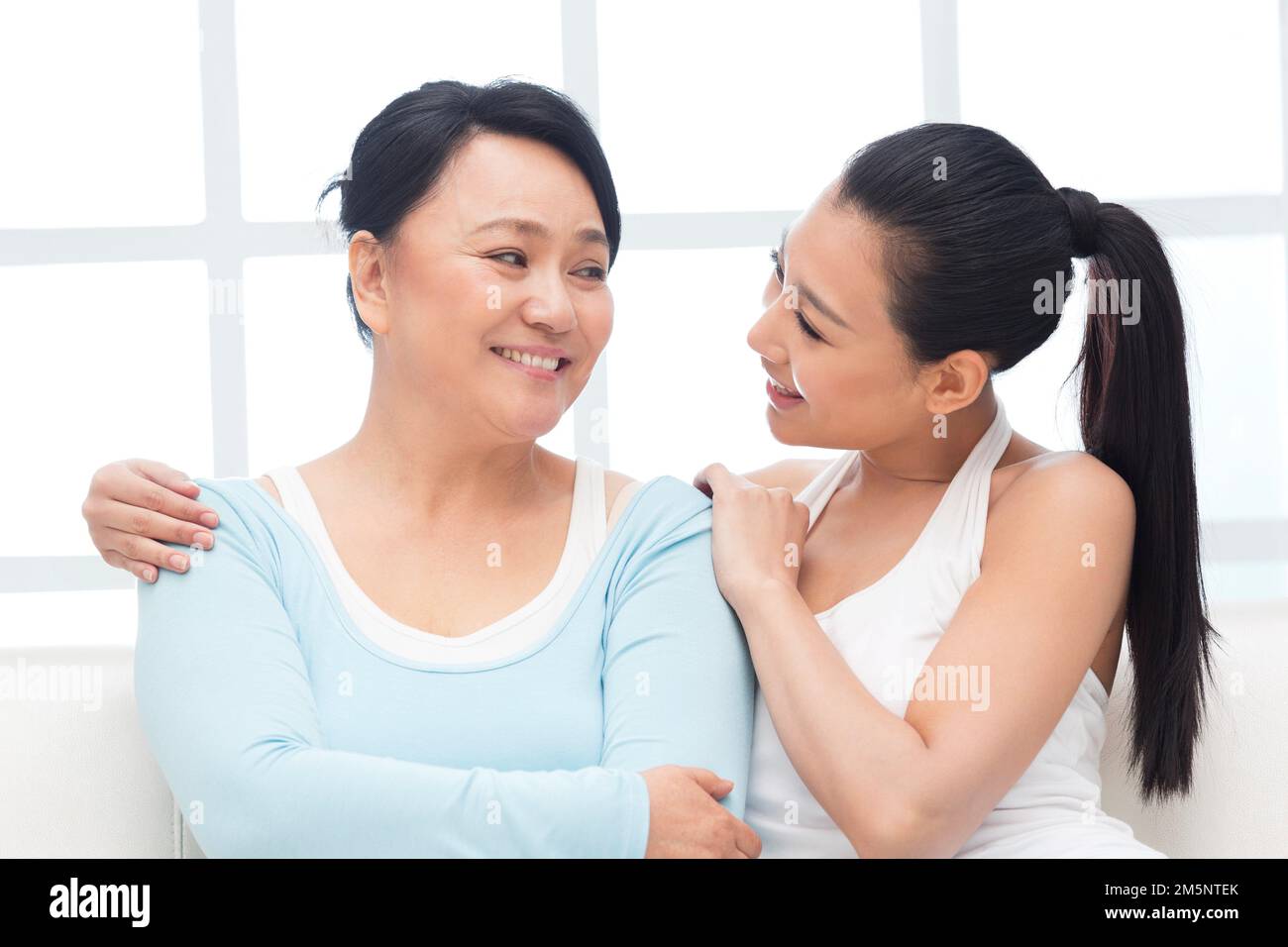 Intimate mother-daughter cuddling on the sofa Stock Photo - Alamy