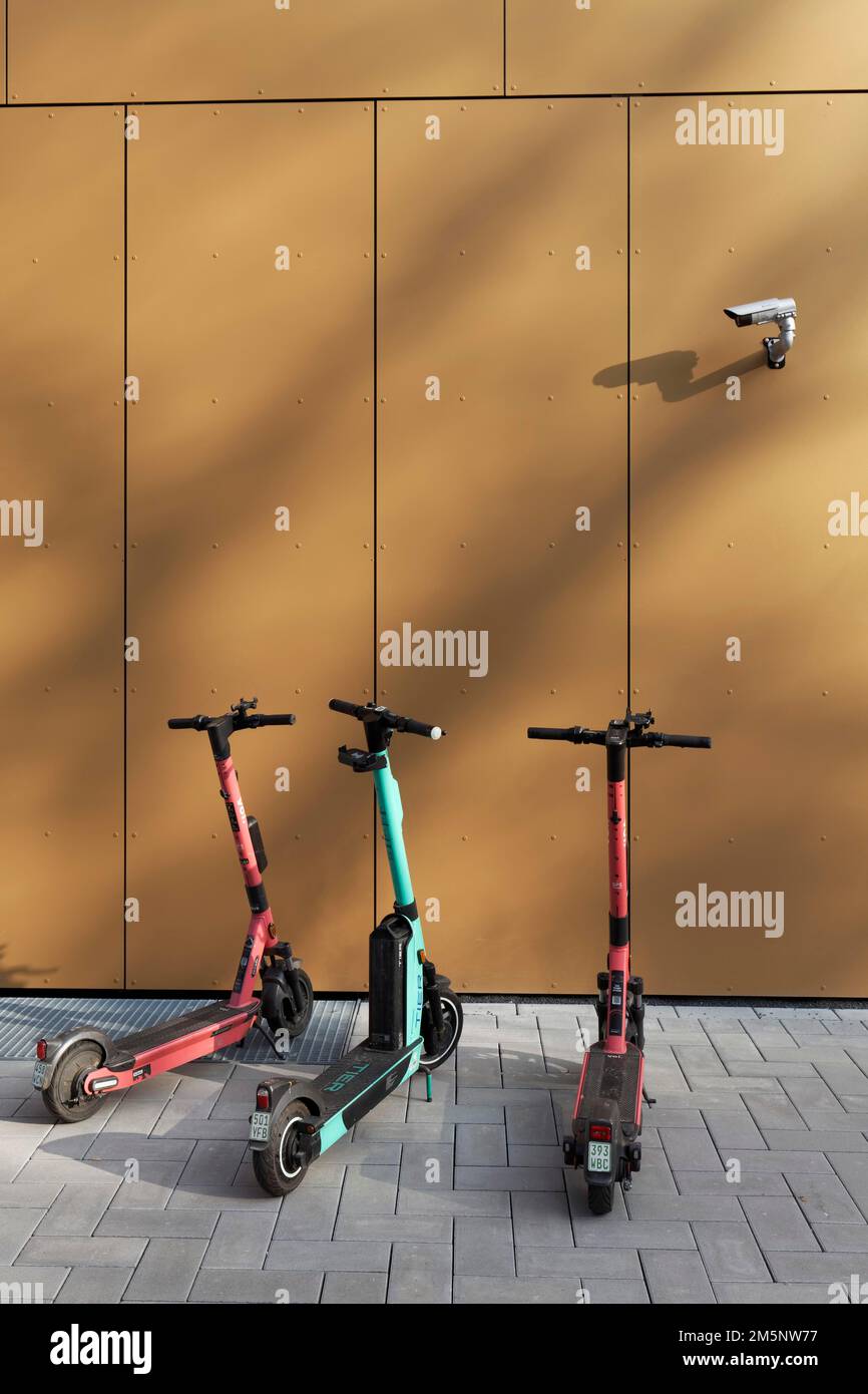 Three e-scooters correctly parked on the pavement, under a surveillance ...