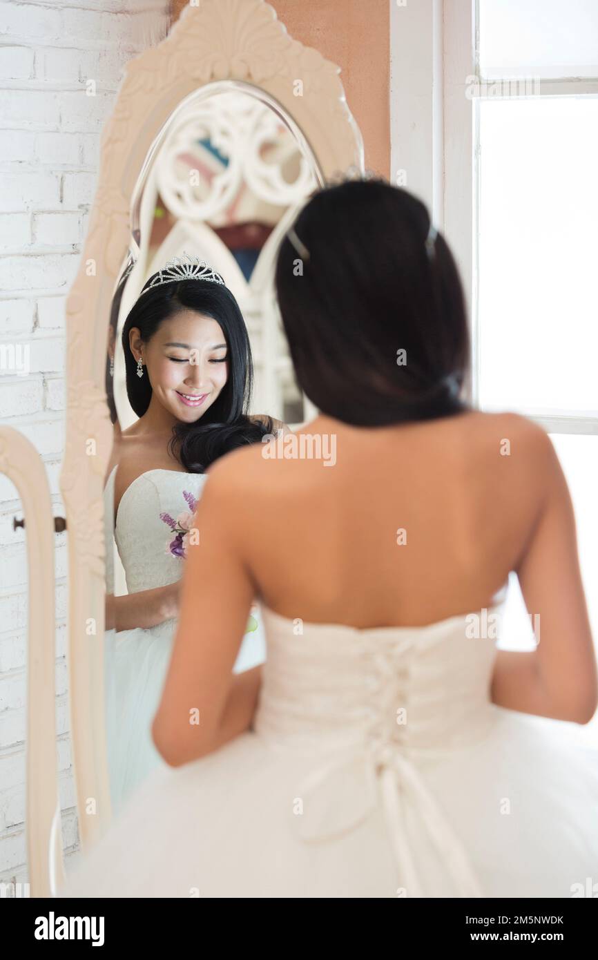 Beautiful bride to look into the mirror Stock Photo - Alamy
