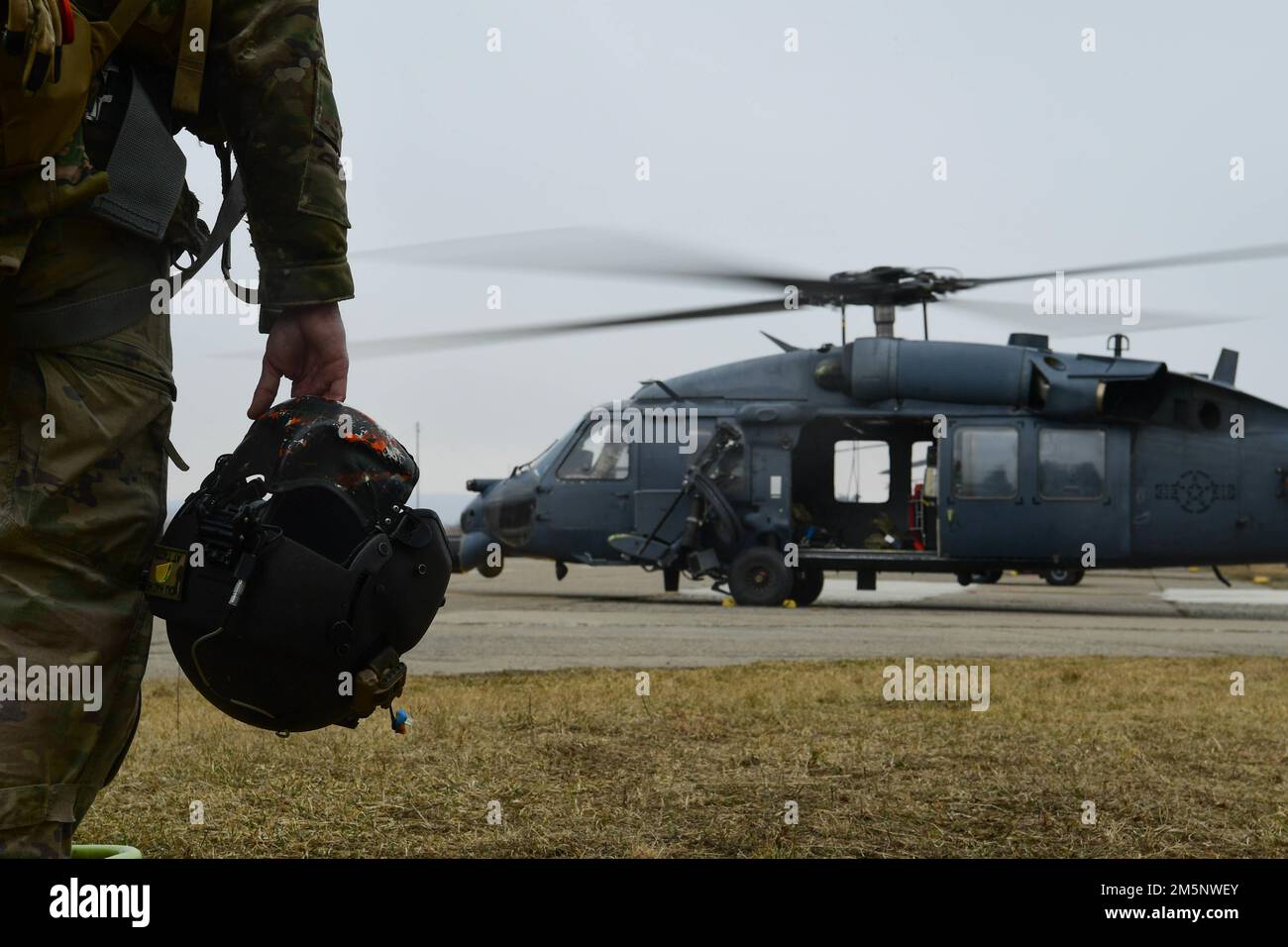 An airman assigned to the 56th Rescue Squadron waits to board an HH-60G ...
