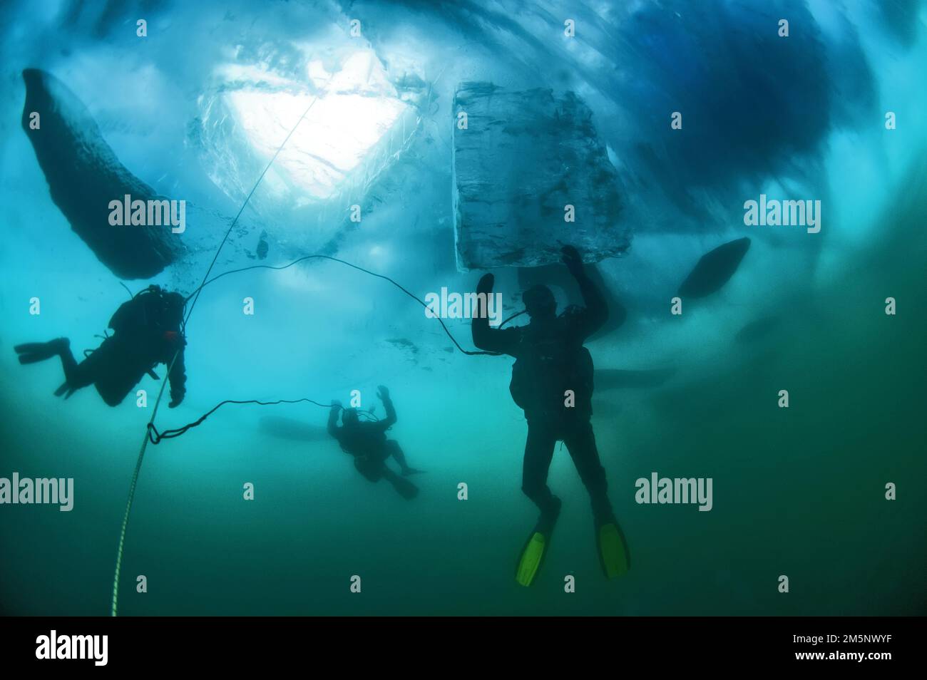 Scuba divers under the ice, Lake Baikal, Olkhon Island, Pribaikalsky ...