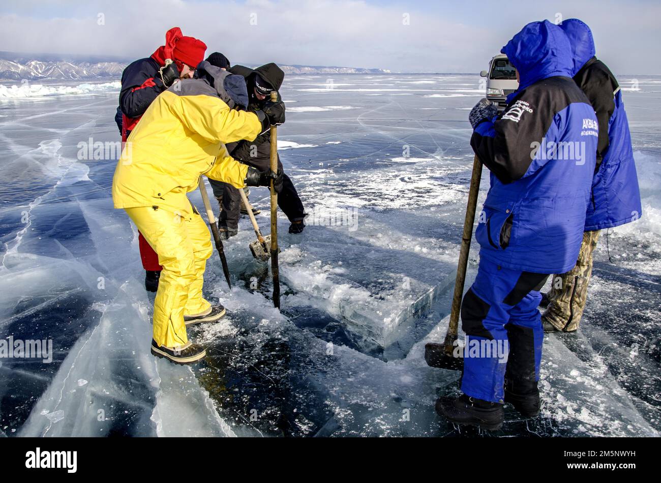 Digging a hole in the ice for scuba diving, Lake Baikal, Olkhon Island ...