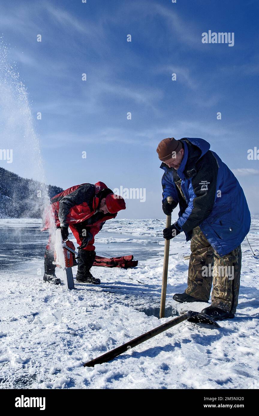 Digging a hole in the ice for scuba diving, Lake Baikal, Olkhon Island ...