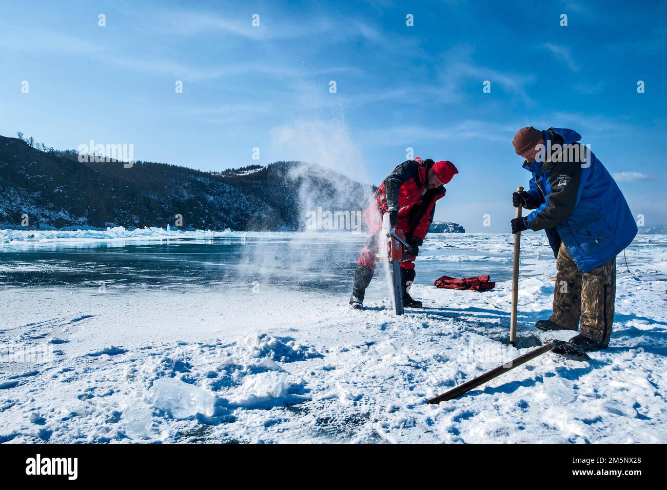 Digging a hole in the ice for scuba diving, Lake Baikal, Olkhon Island ...