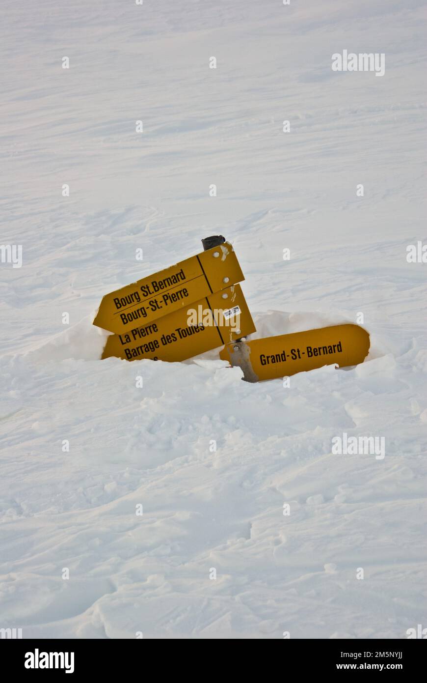 A vertical shot of a sign buried in a big layer of snow showing the ...