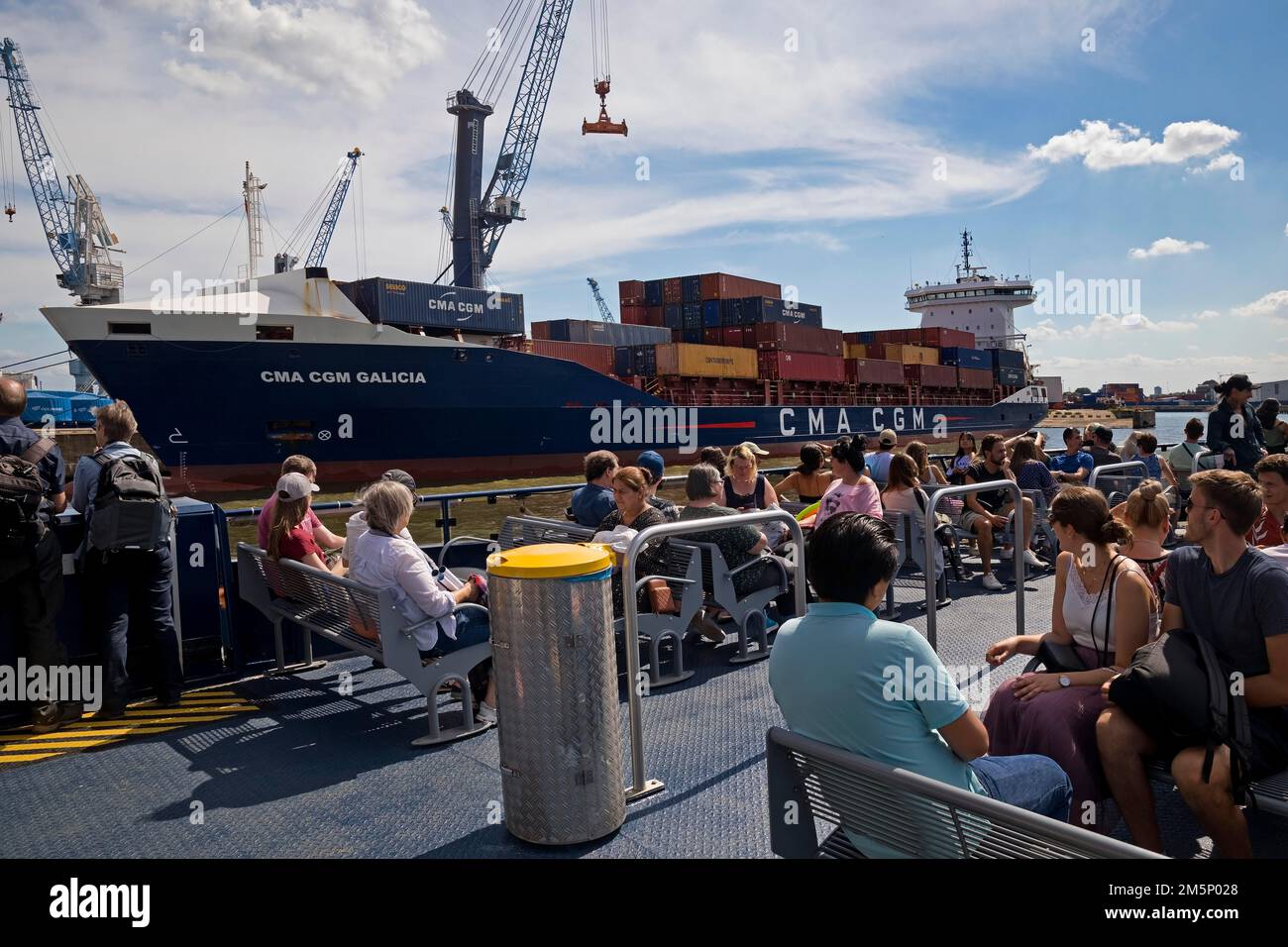 Passengers on a harbour ferry look at a container ship in Steinwerder ...