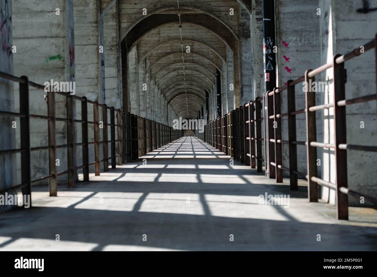 A passage for pedestrians that is under a bridge for trains Stock Photo ...