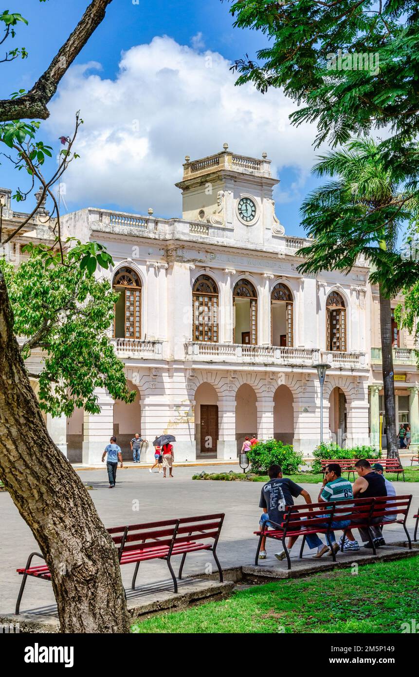 The former Palacio Municipal building is framed in trees and benches of ...