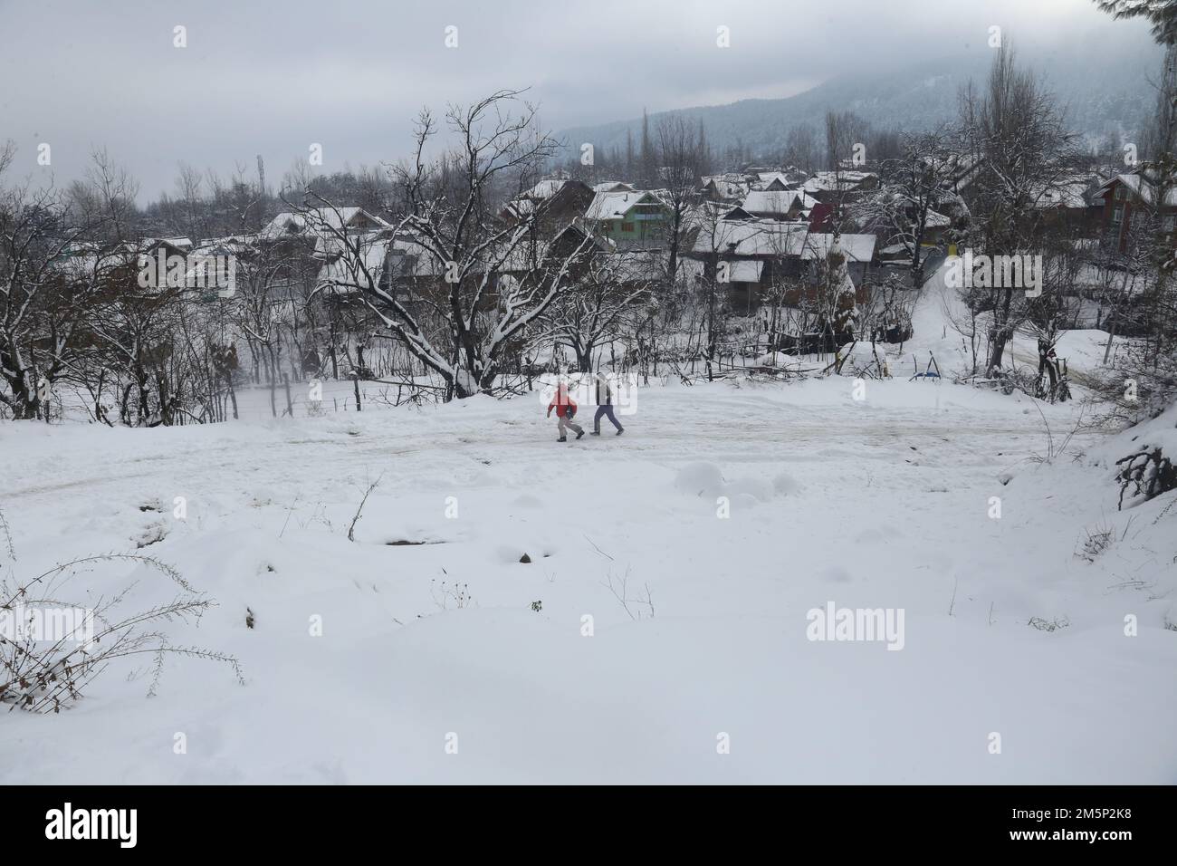 Srinagar, India. 30th Dec, 2022. People walk in snow covered hilly area ...