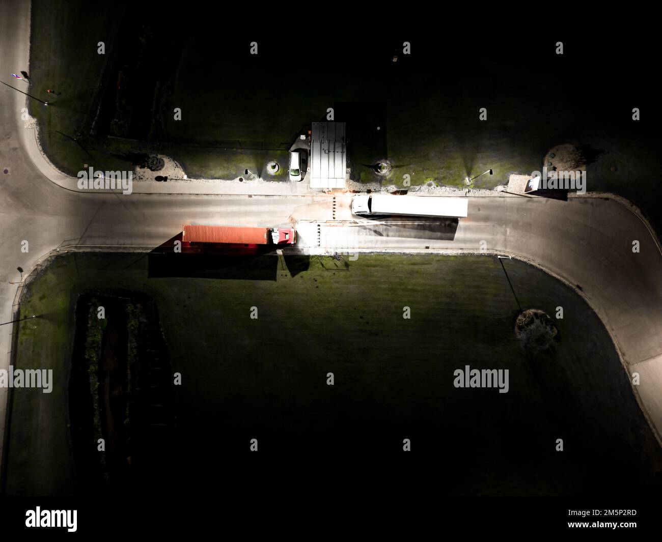 Aerial view of a sharp turn on a mountain road among green forest trees ...