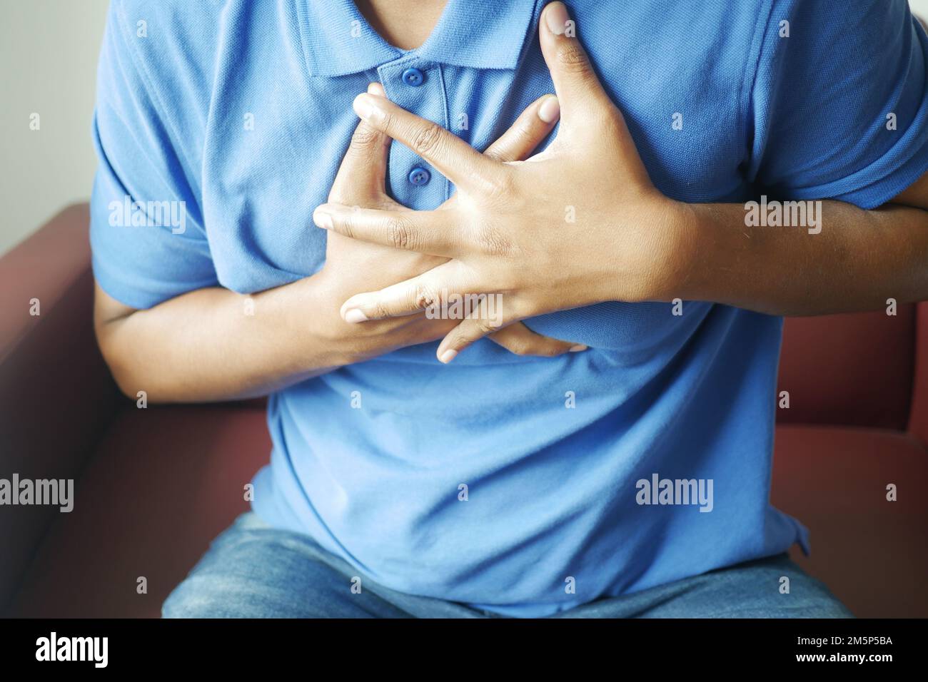 young man suffering pain in heart and holding chest with hand Stock ...