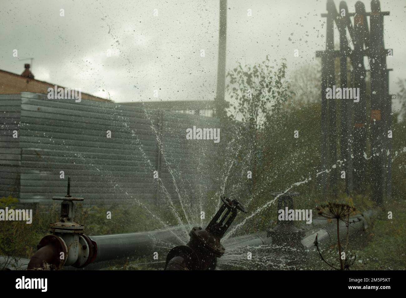 Pipe breaking with water. Pipeline accident. Hot water flows from pipes ...