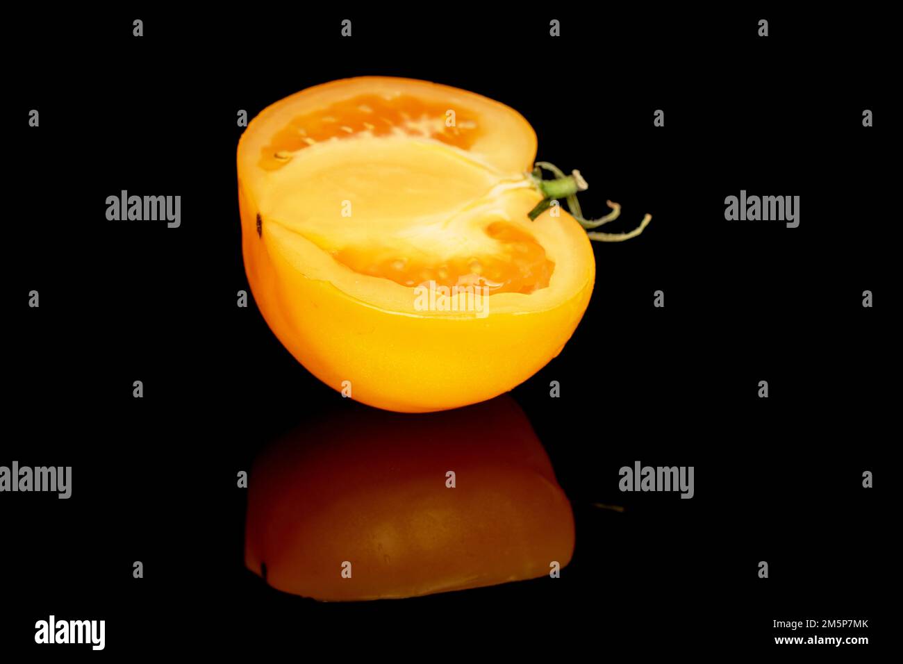 One halve of fresh organic, juicy tomatoes, close-up, isolated on black ...