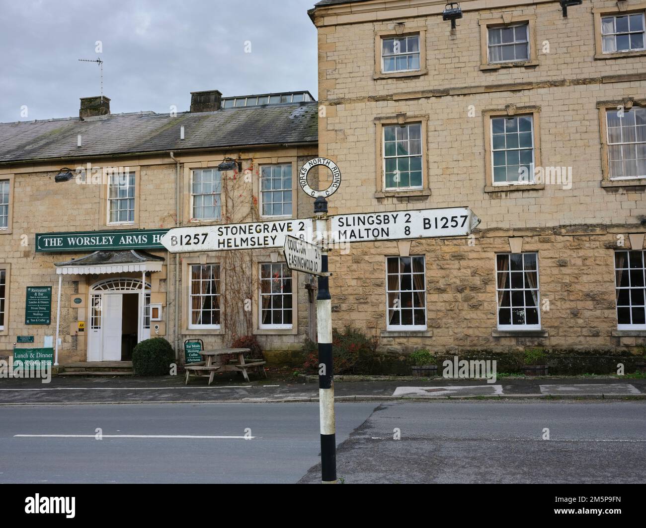 Old fashioned road sign on the B1257 in the centre of Hovingham, North ...