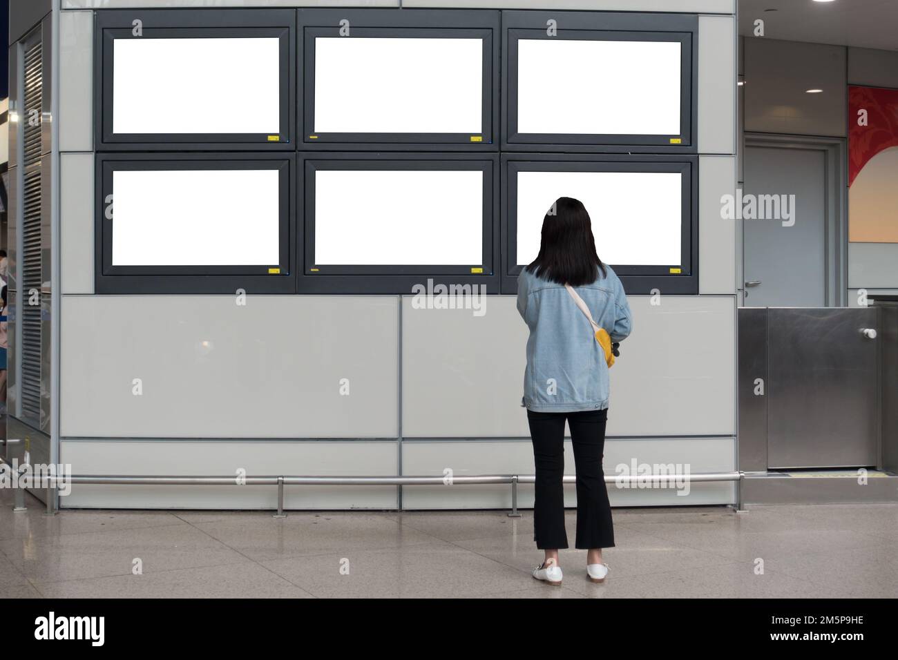 A woman looking at white screens on a wall Stock Photo - Alamy