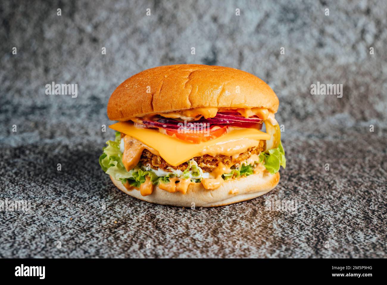 A vertical closeup of a Fresh and juicy double beef cheeseburger with ...