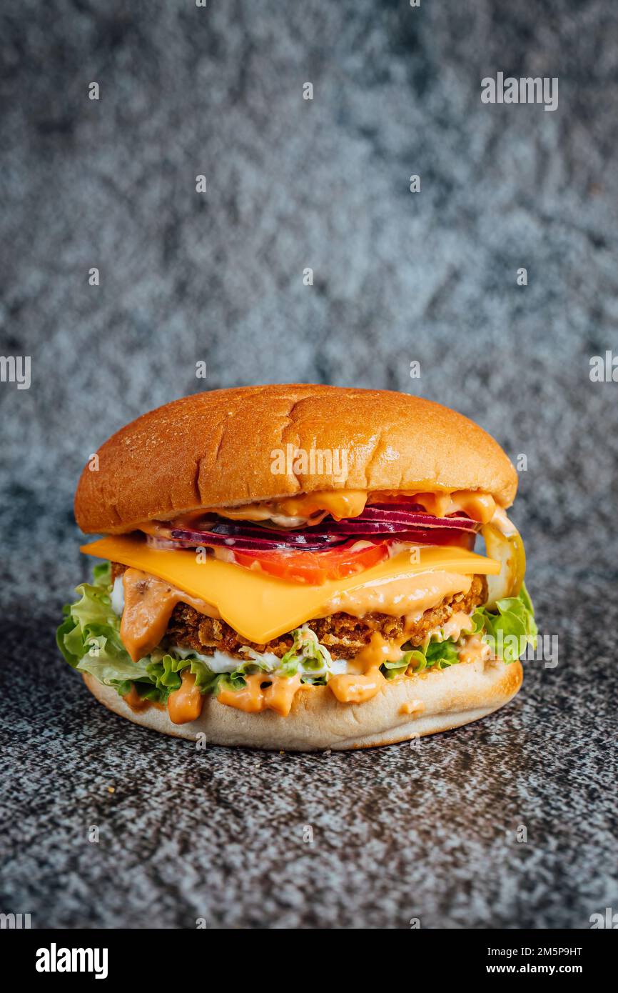A vertical closeup of a Fresh and juicy double beef cheeseburger with ...