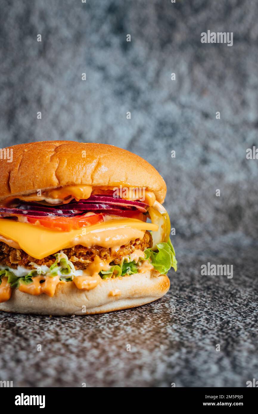 A vertical closeup of a Fresh and juicy double beef cheeseburger with ...