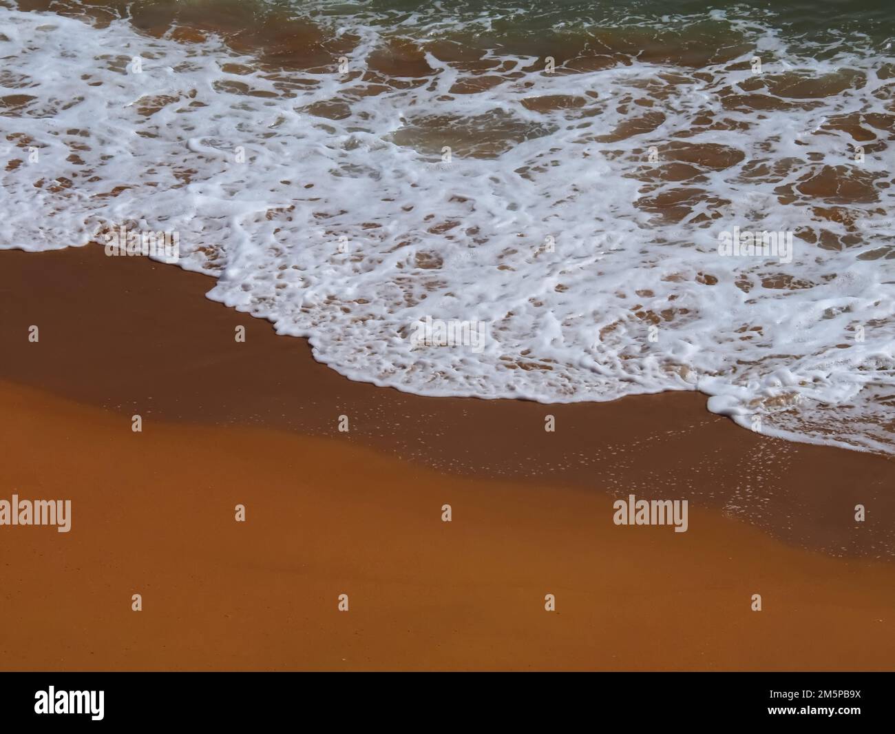 Aerial view of surf in sea meets red sand beach Stock Photo - Alamy