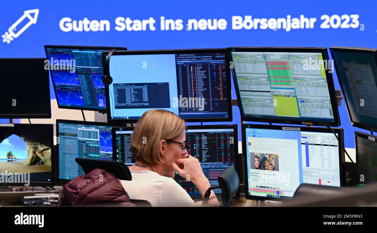 30 December 2022, Hessen, Frankfurt/Main: A trader watches her monitors ...