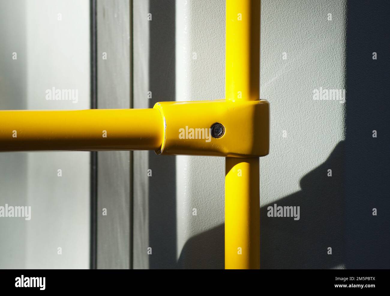 Close-up of yellow handrail inside a city bus Stock Photo - Alamy