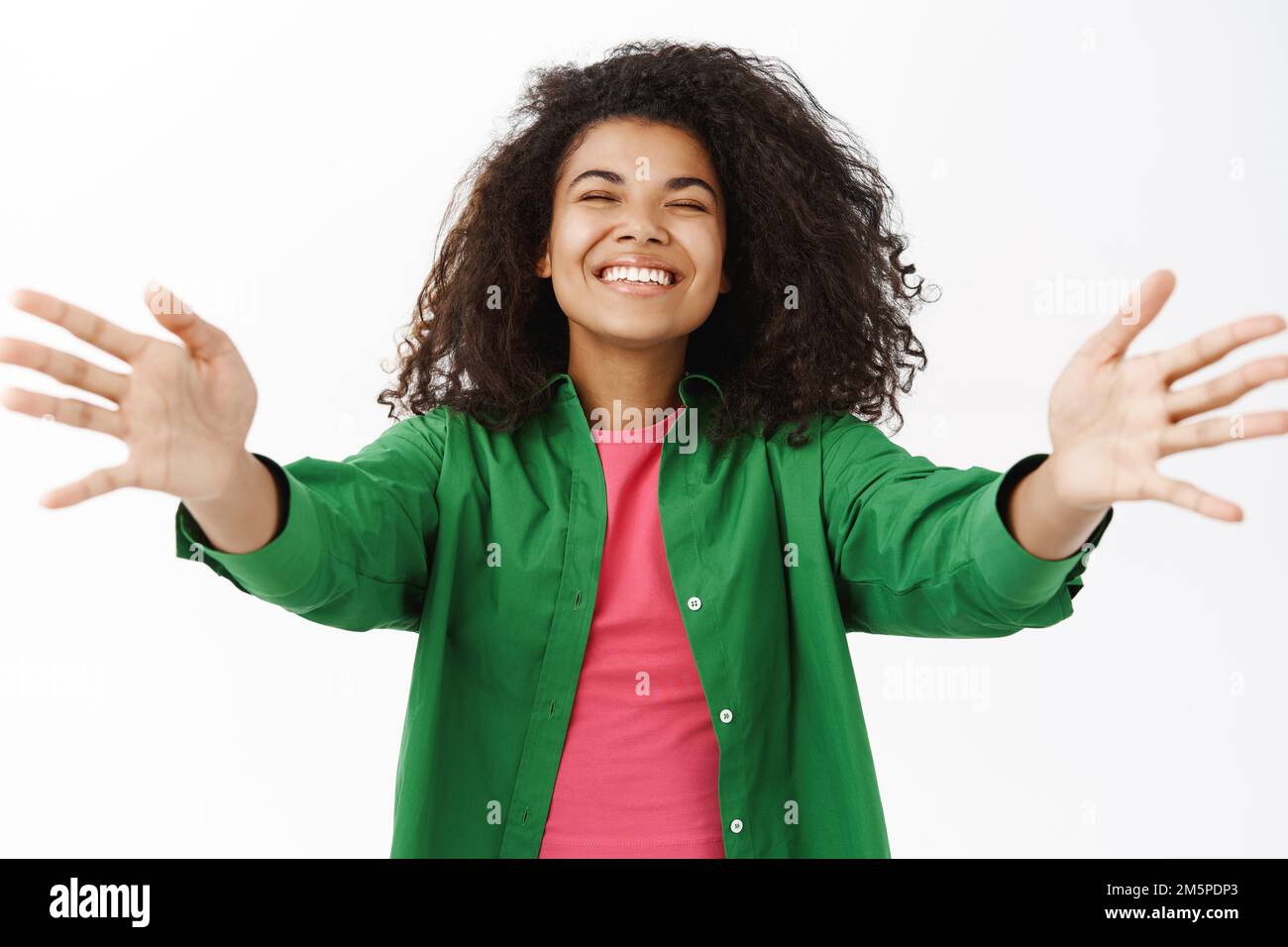 Portrait of smiling cute young woman reaching her hands for hug ...