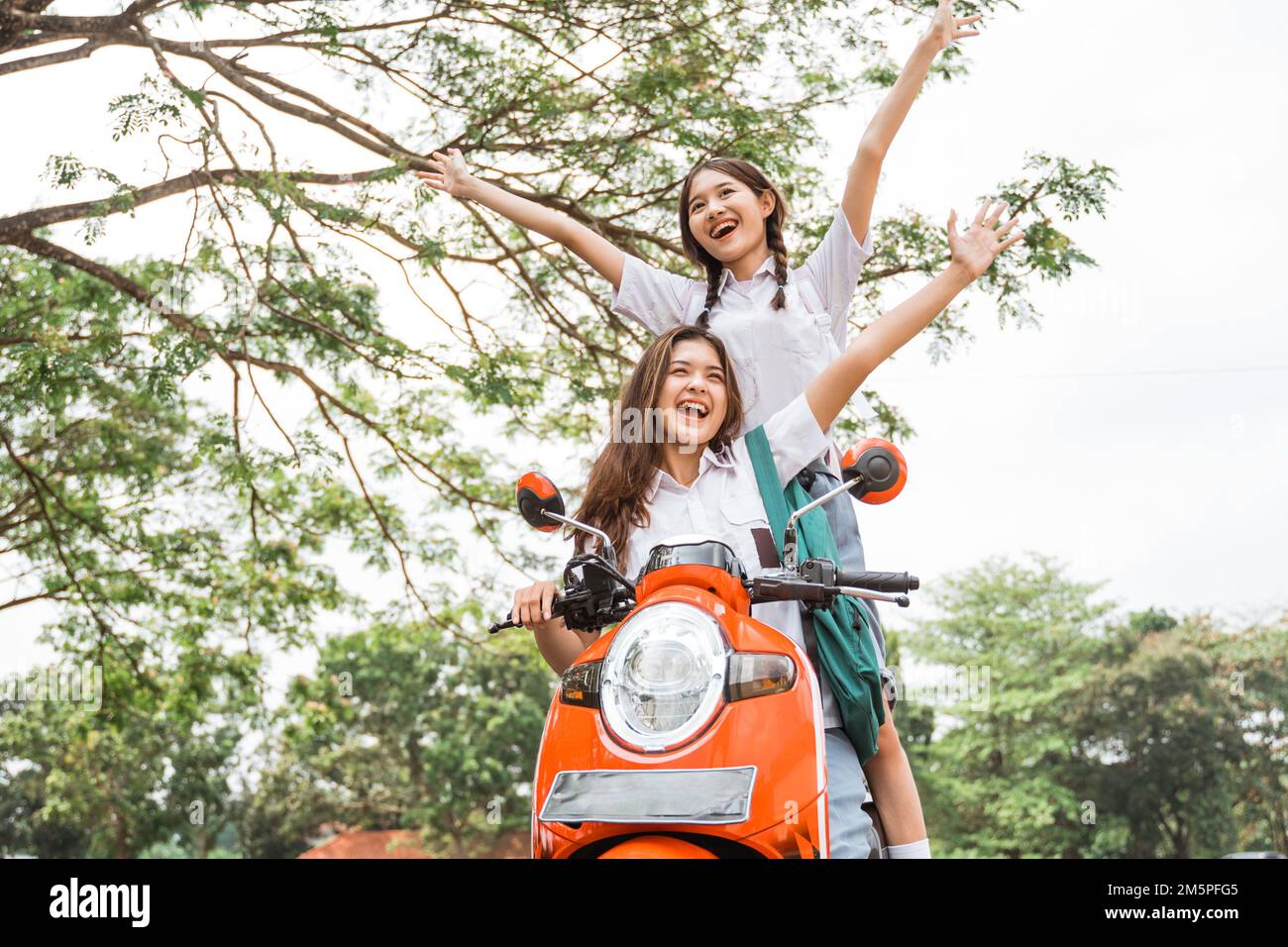 Two high school girls riding motorbikes standing without helmets Stock ... Two high school girls riding motorbikes standing without helmets Stock ...