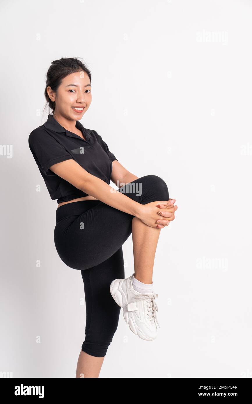 side view of woman standing stretching legs holding one leg Stock Photo ...