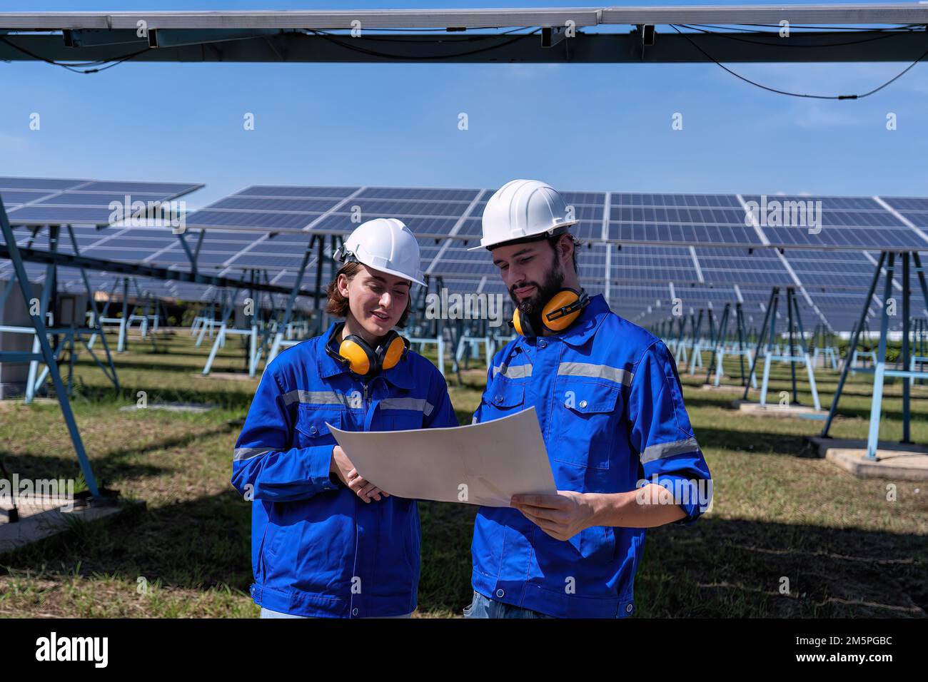 Maintenance engineer at solar farm looking drawing discuss on expansion ...