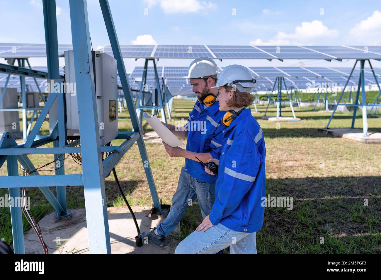 Maintenance engineer at solar farm trouble shooting looking at inverter ...