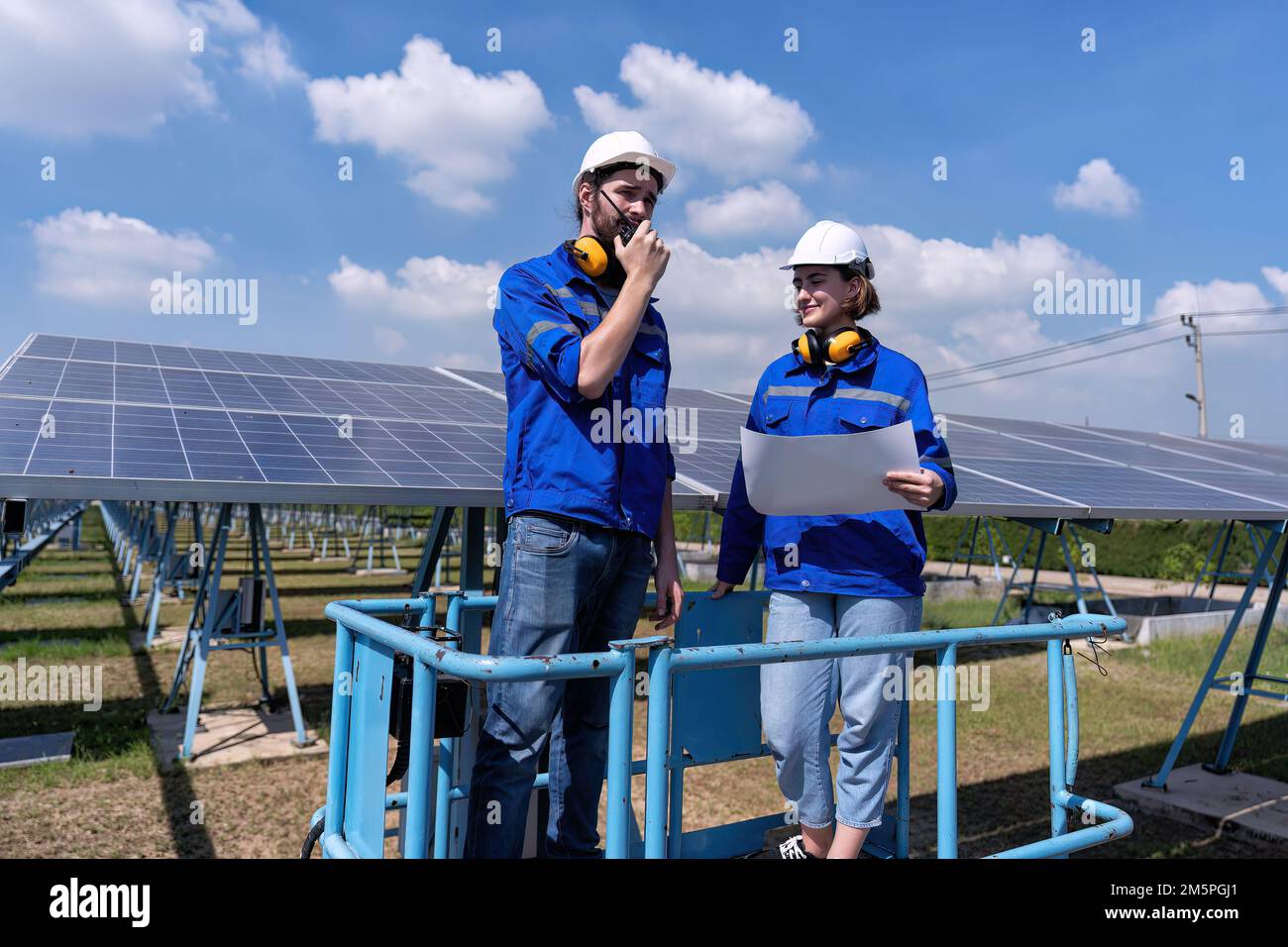 Maintenance engineer at solar farm stand on scissor lift inspection ...