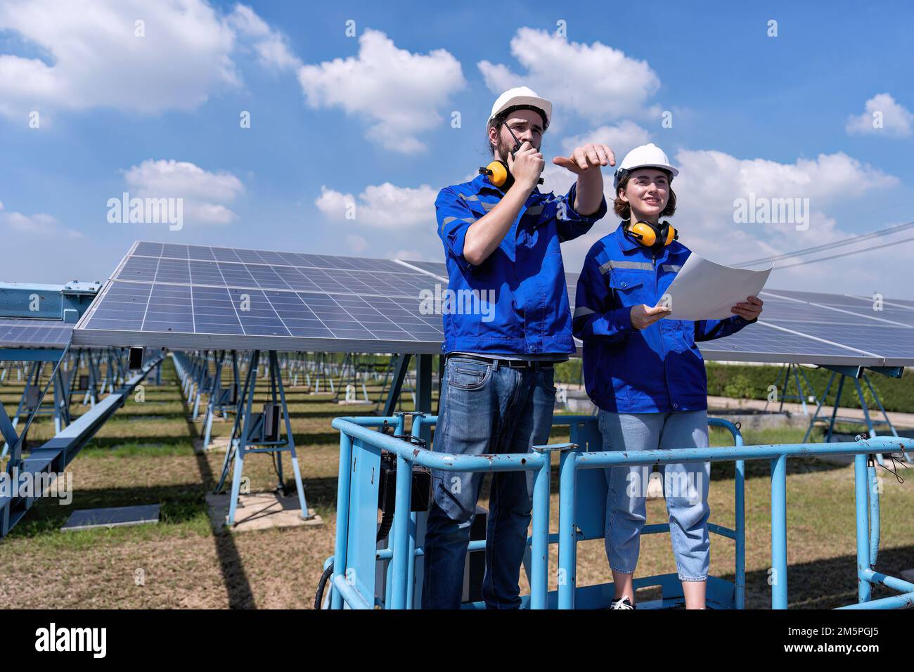 Maintenance engineer at solar farm stand on scissor lift inspection ...