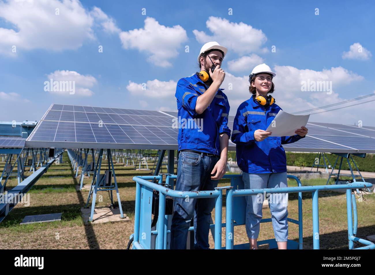 Maintenance engineer at solar farm stand on scissor lift inspection ...