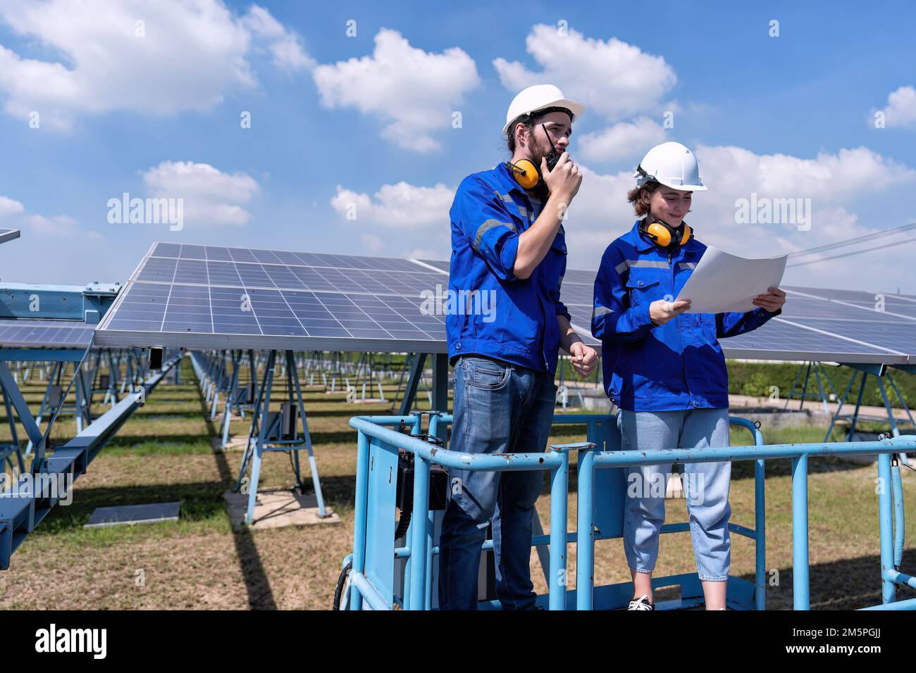 Maintenance engineer at solar farm stand on scissor lift inspection ...