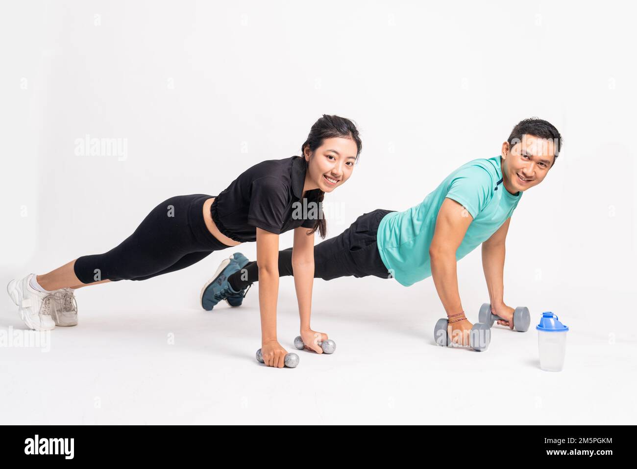 side view of man and woman push ups with dumbbells Stock Photo - Alamy