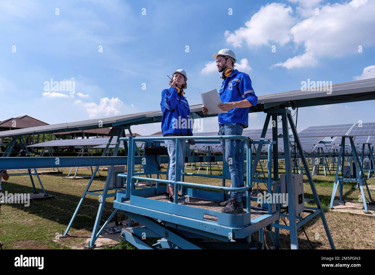 Maintenance engineer at solar farm stand on scissor lift inspection ...
