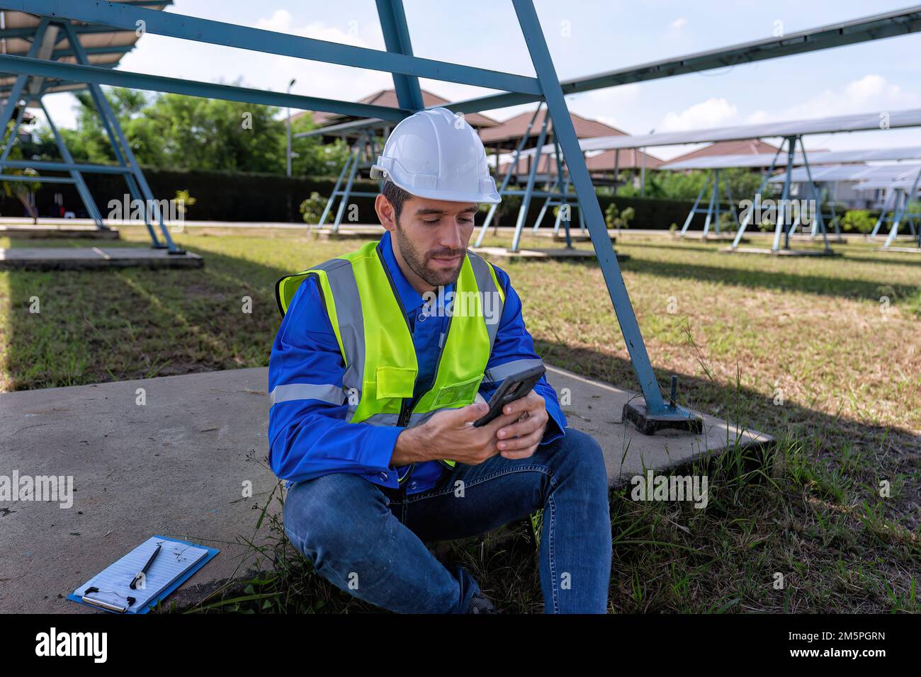 Engineer at solar farm on break time sitting look social media from ...