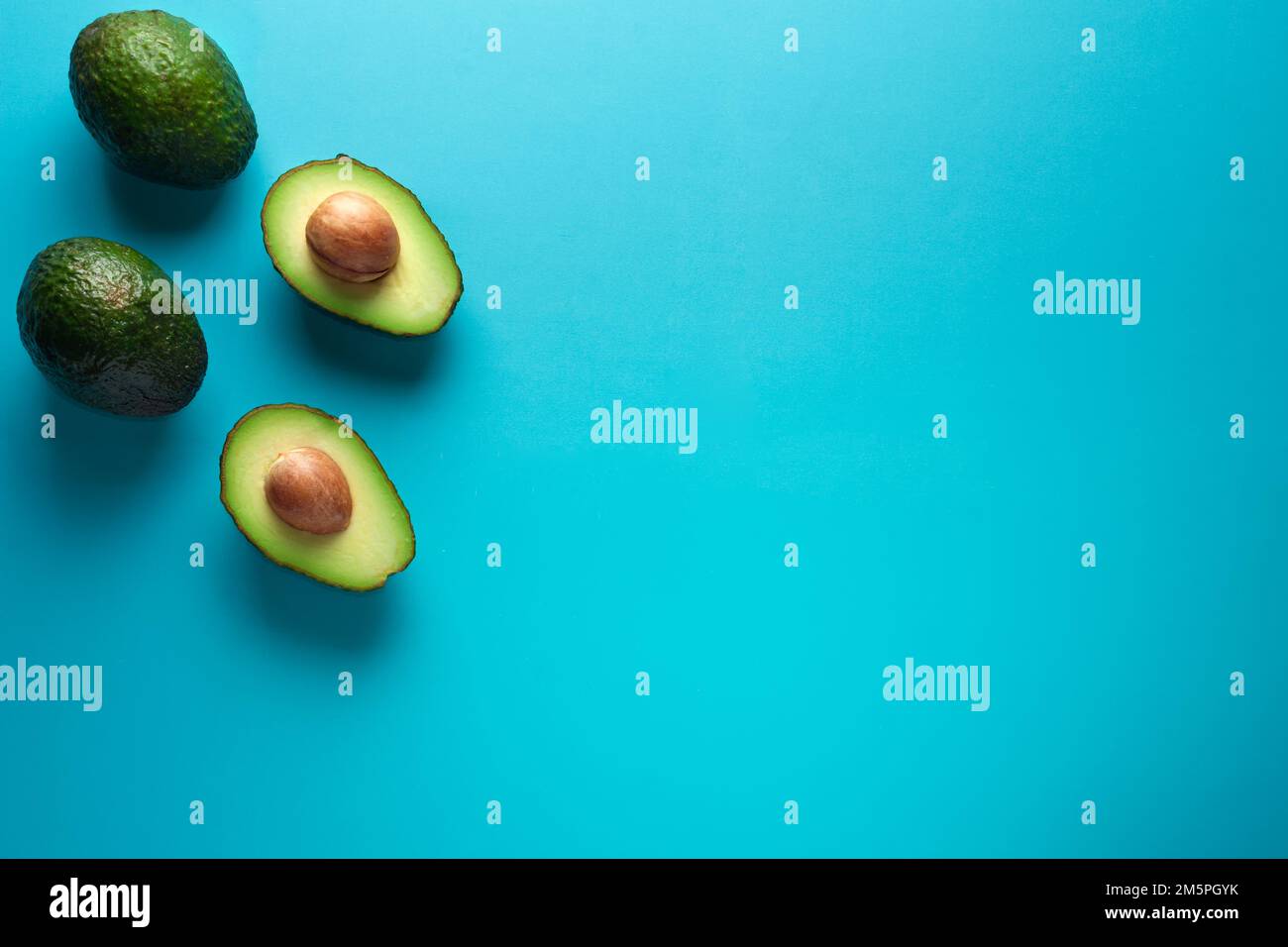 Fresh avocados on a blue background. Banner with free space for text ...