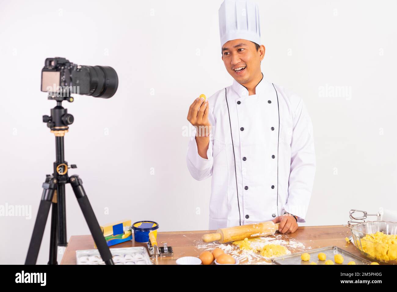 male chef food vlogger presenting cake to camera Stock Photo - Alamy