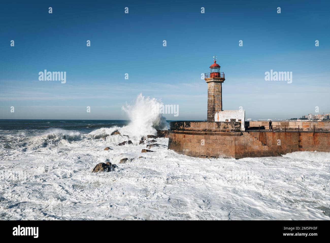 A lighthouse on the shore of the Atlantic Ocean in the city of Porto ...