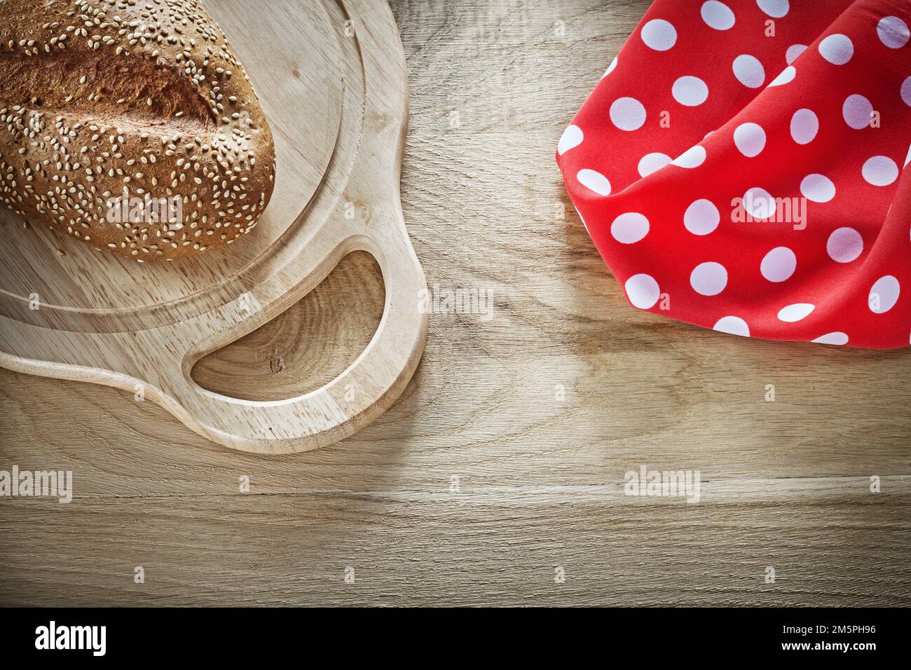 Bread carving board red polka-dot tablecloth on wooden background Stock ...